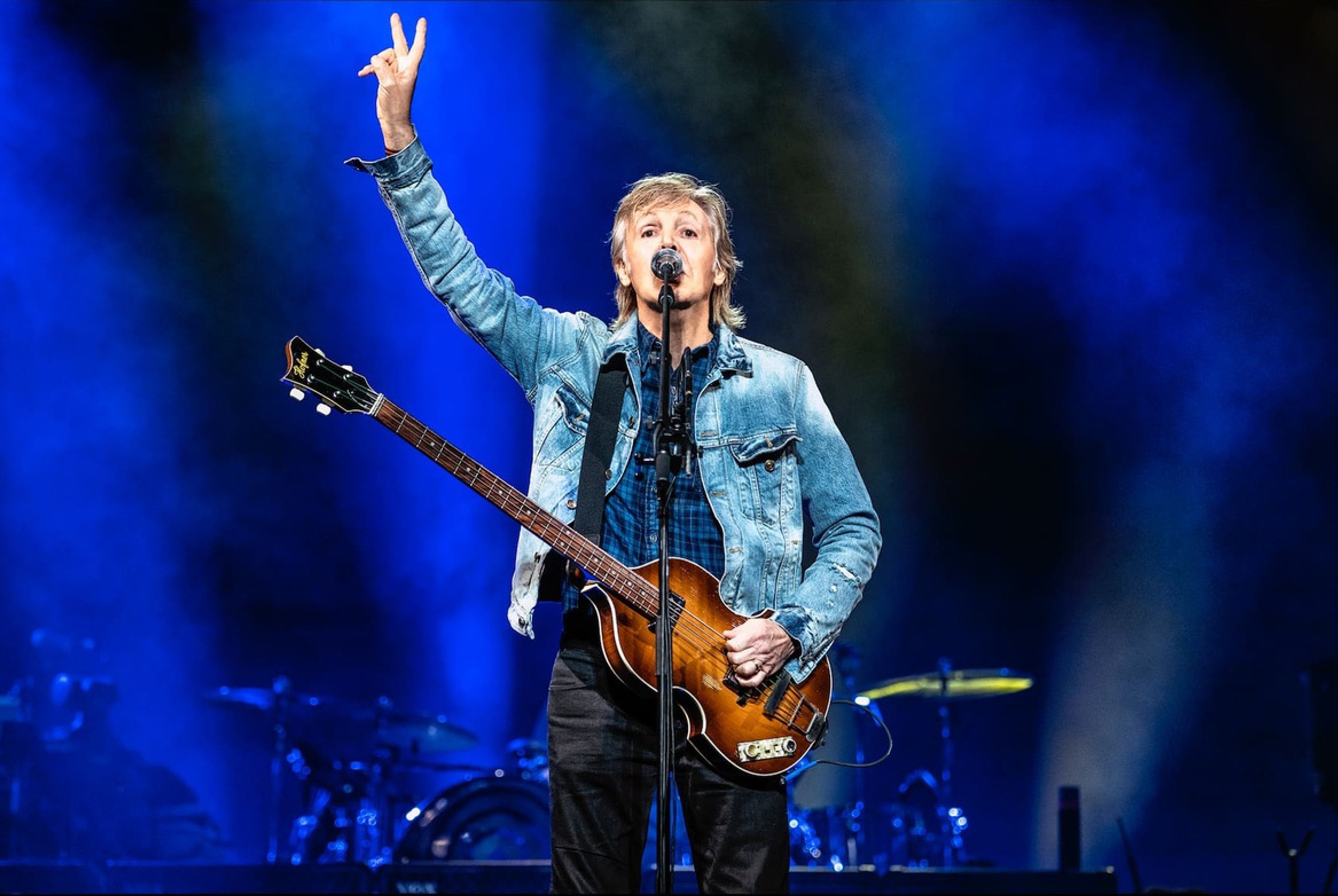 Photo of Paul performing in 2019 with his Hofner bass guitar and making ...